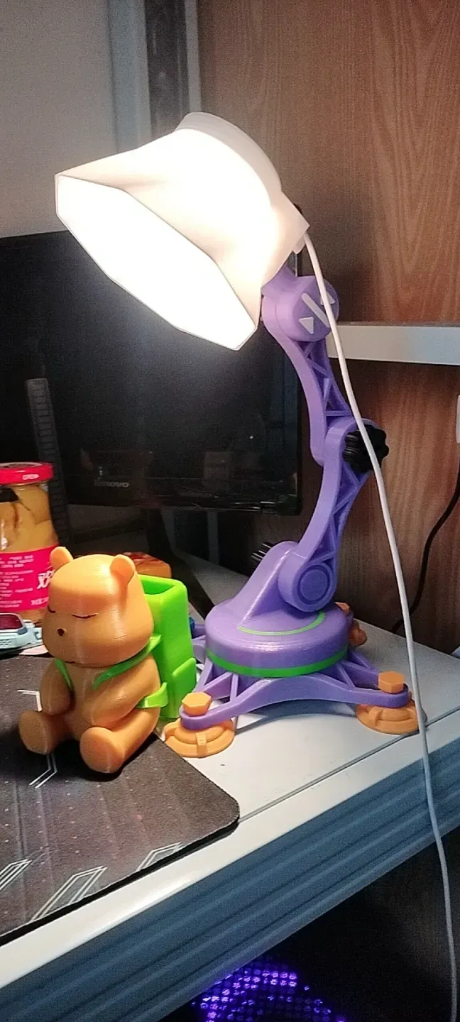 A robotic arm phone holder supports the Bambu Lab Desk Lamp module with ...