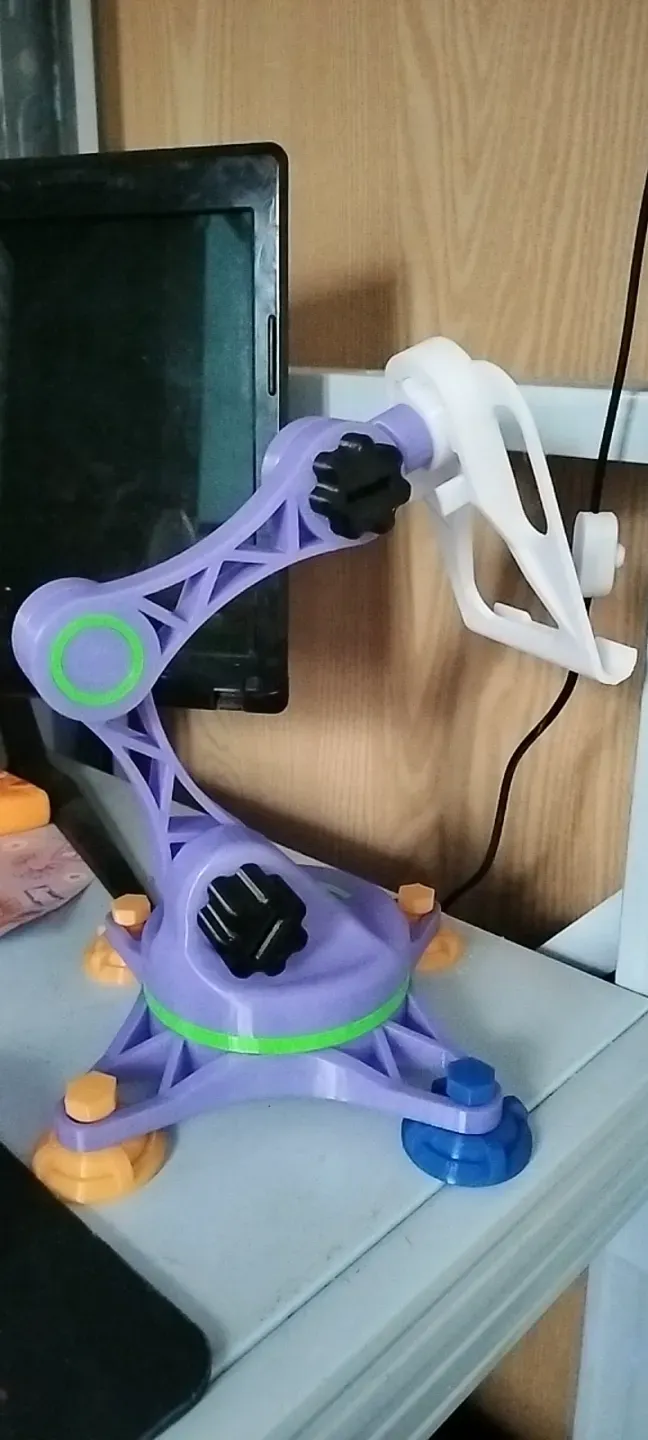 A robotic arm phone holder supports the Bambu Lab Desk Lamp module with ...