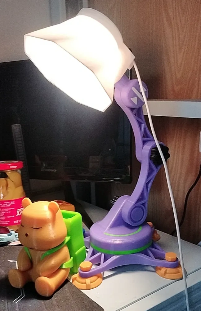 A robotic arm phone holder supports the Bambu Lab Desk Lamp module with ...