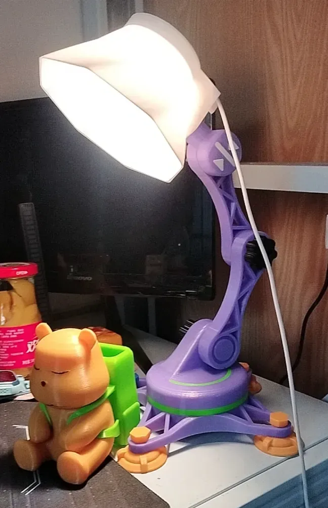 A robotic arm phone holder supports the Bambu Lab Desk Lamp module with ...